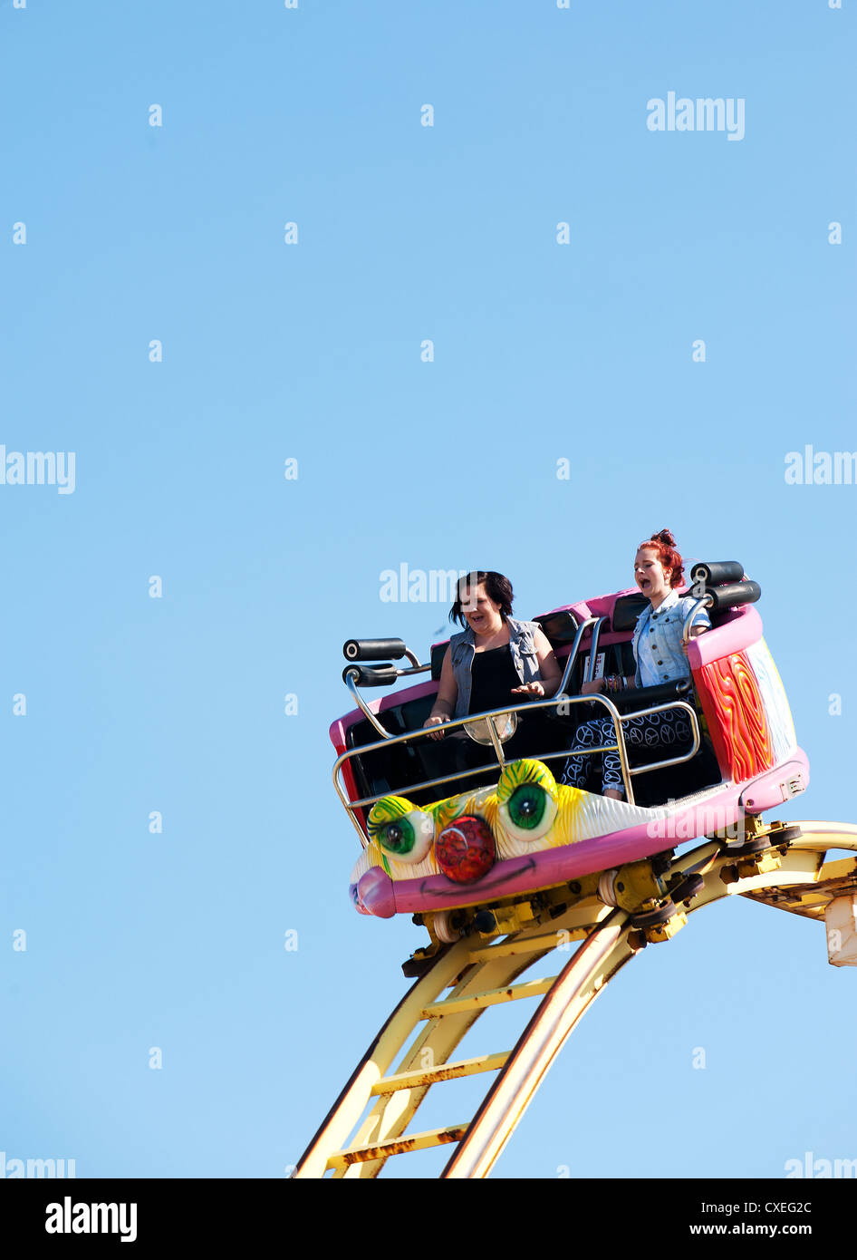 Two girls enjoying themselves on a fairground ride on Brighton Pier ...