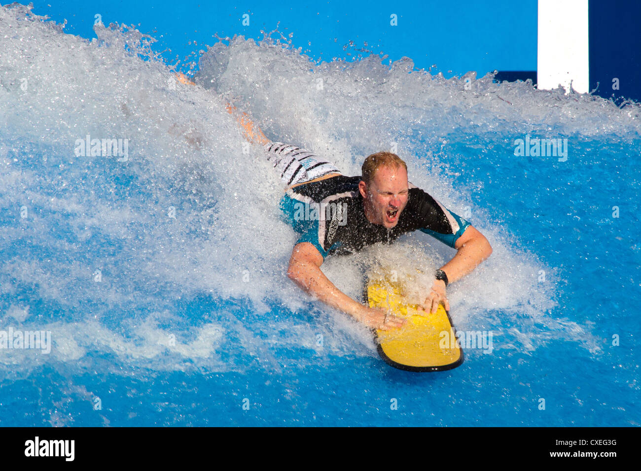 Surfer young man enjoy surfing on artificial wave at "Wave House ...