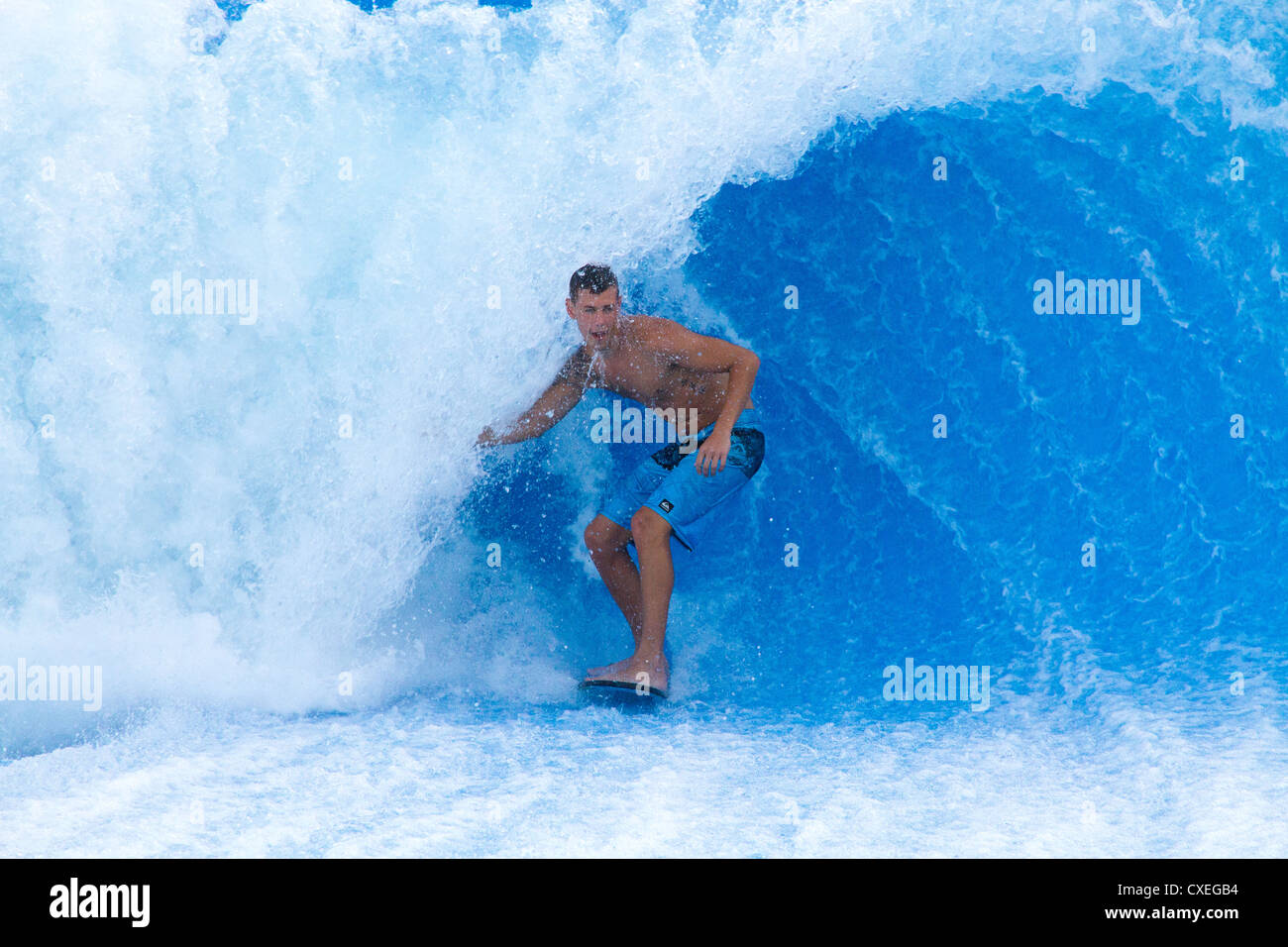 Surfer young man enjoy surfing on artificial wave at "Wave House ...
