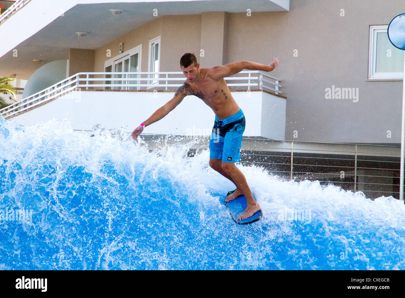 Surfer young man enjoy surfing on artificial wave at "Wave House ...