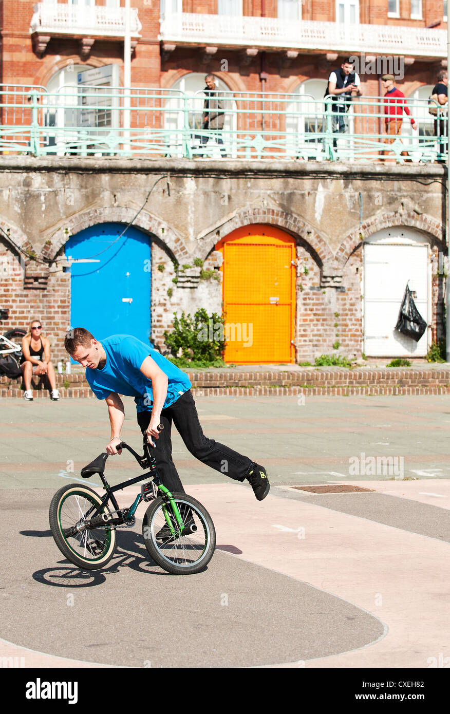 A man performing freestyle tricks tricks on a flatland BMX bicycle ...