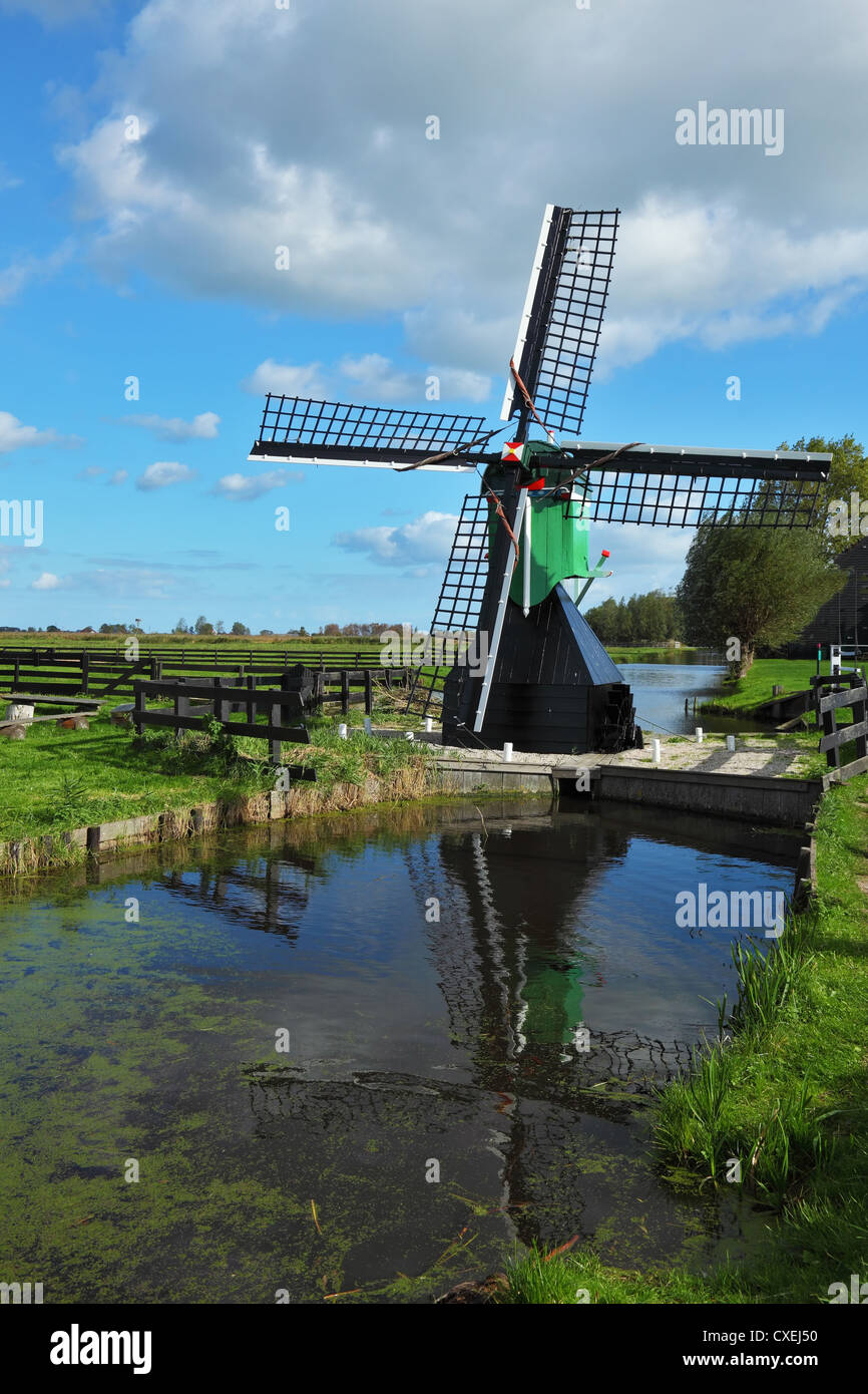 The ancient windmill is reflected in pond Stock Photo - Alamy