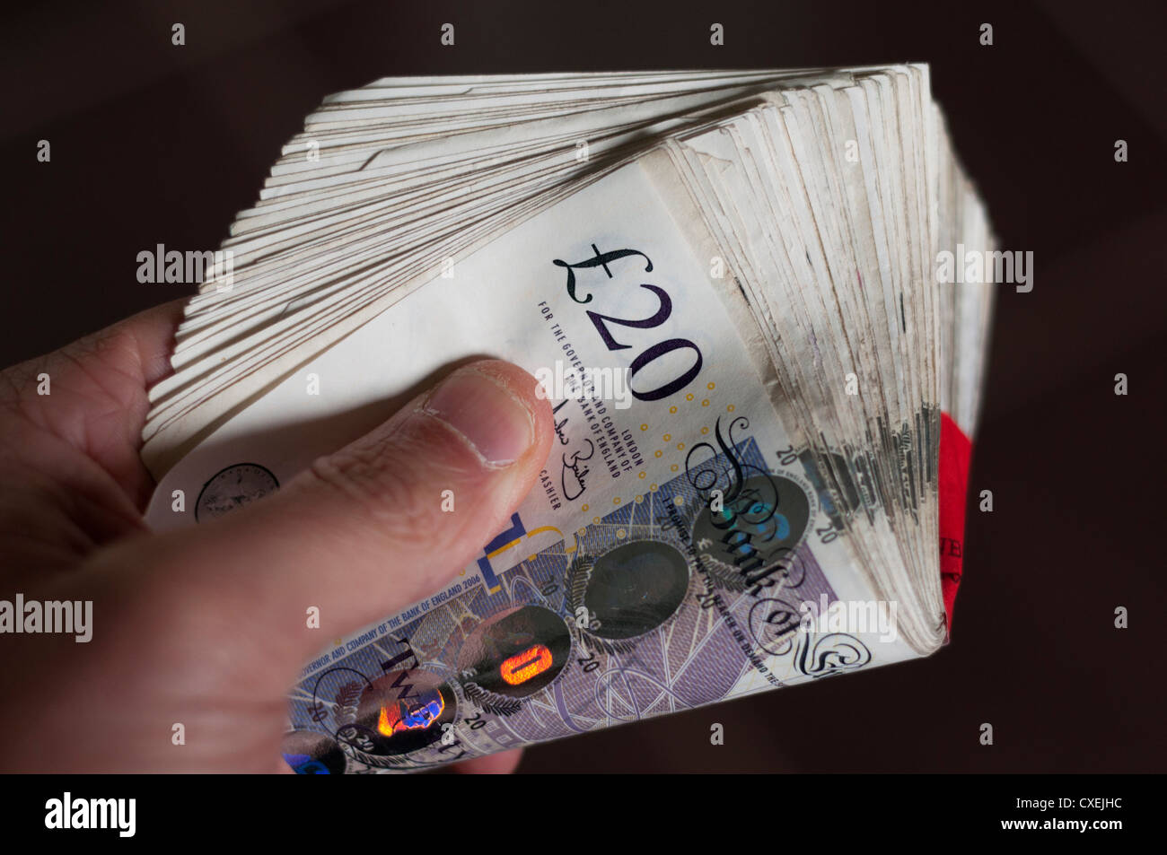 Wad of twenty pound notes cash in hands Stock Photo - Alamy