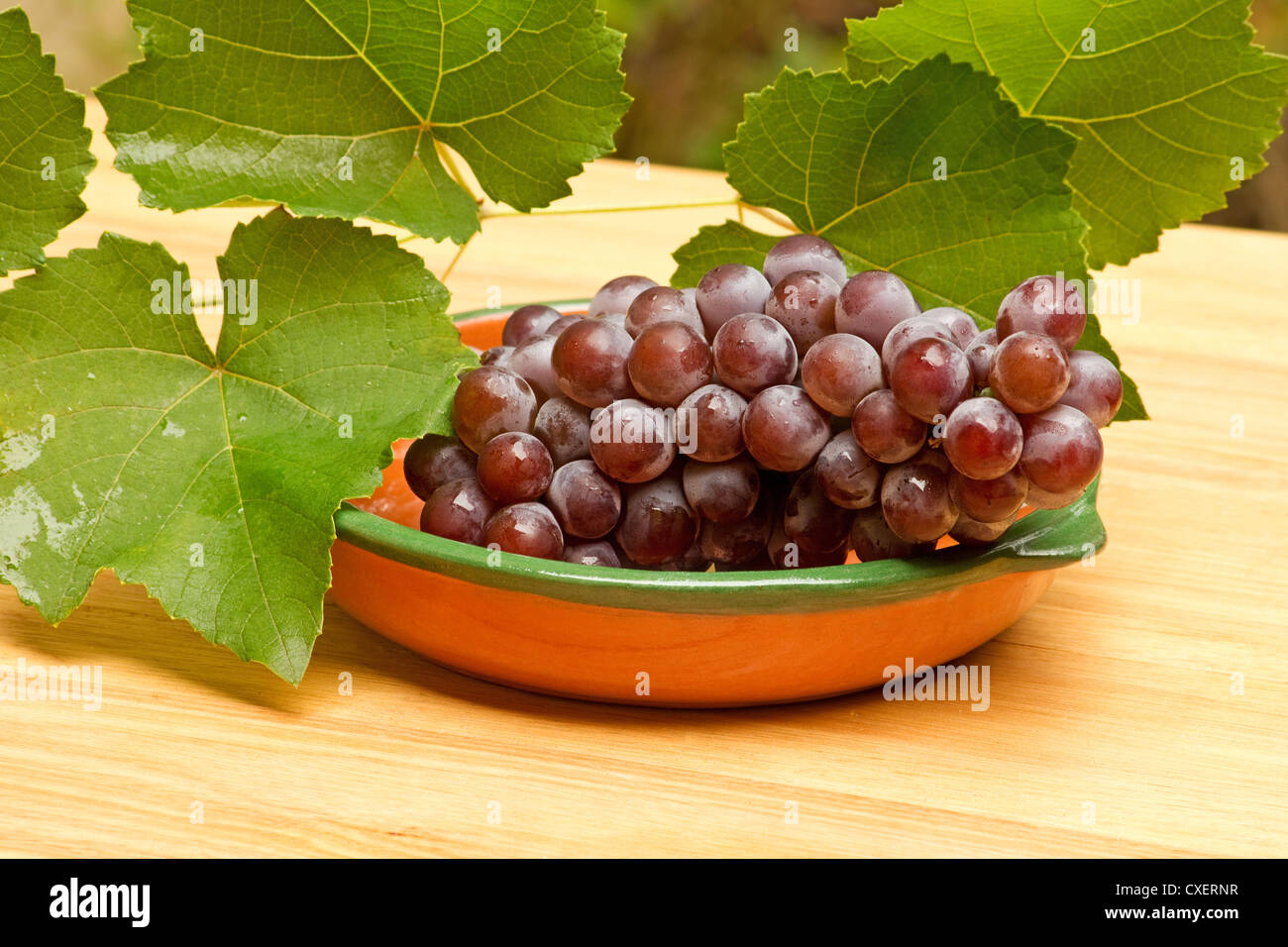 Red table grapes and leaves on wooden table Stock Photo - Alamy
