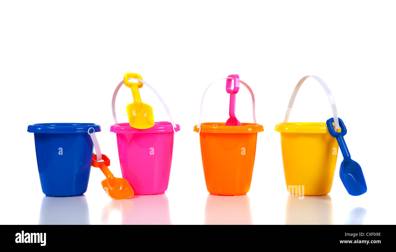 Row of brightly colored beach buckets and shovels on a white background ...