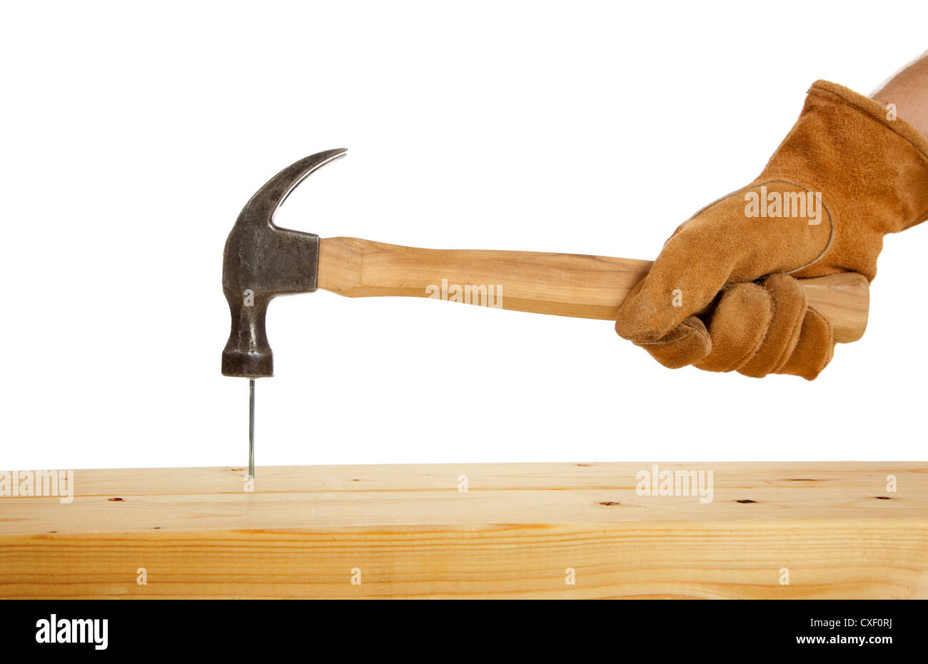 Work gloved hand hammering in a nail in a block of wood Stock Photo - Alamy
