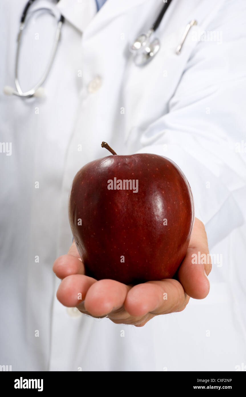 Physician's hand holding out a red apple Stock Photo - Alamy