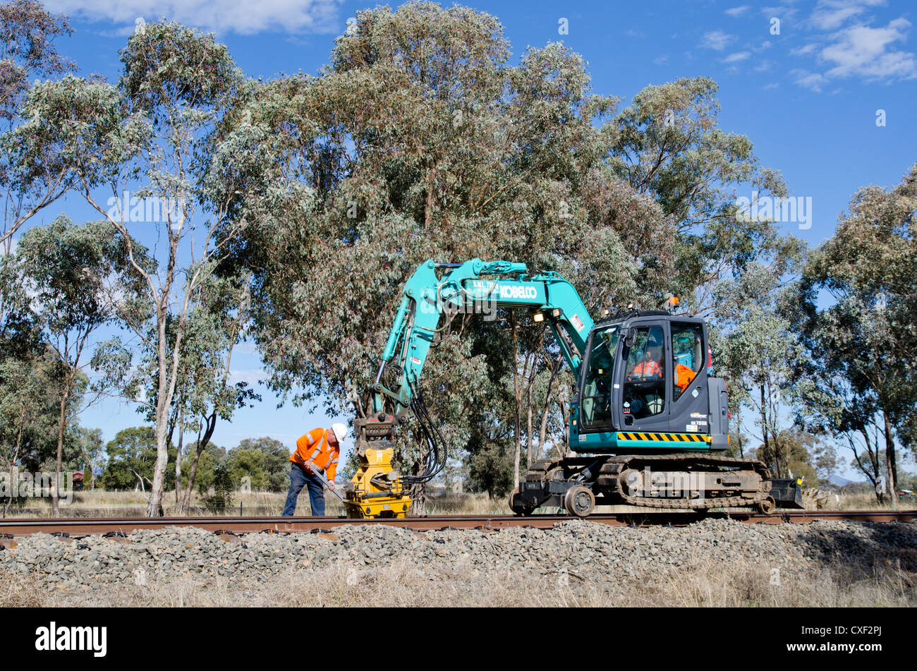 Machine positioning new iron railway sleepers Stock Photo - Alamy