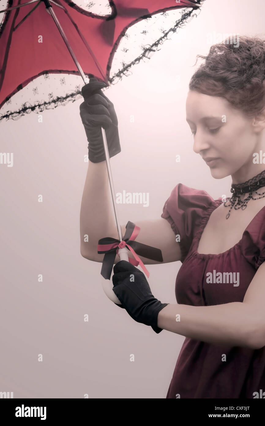 a woman with a red period dress and a red parasol Stock Photo - Alamy