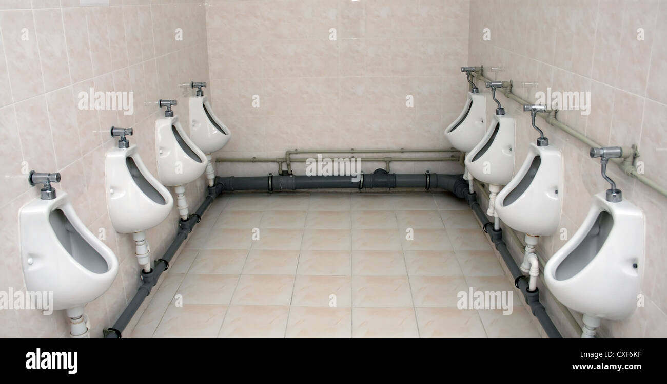 Two rows of urinals in a toilet Stock Photo - Alamy