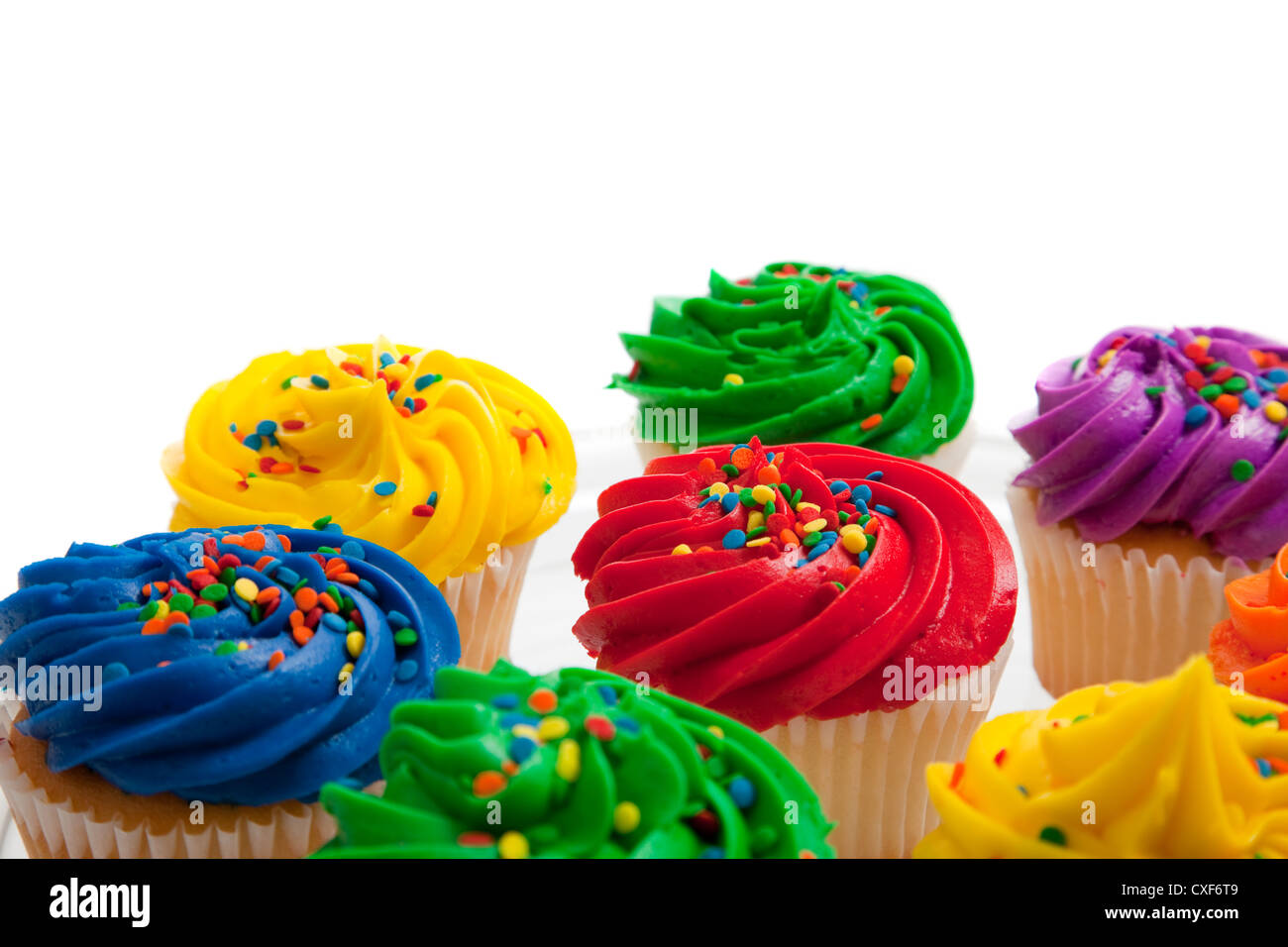 Brightly colored frosted cupcakes on a white background Stock Photo - Alamy