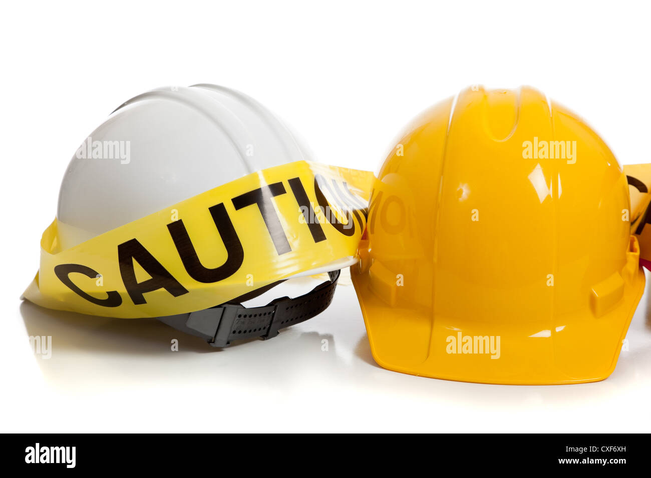 White and yellow hard hats with caution tape Stock Photo - Alamy