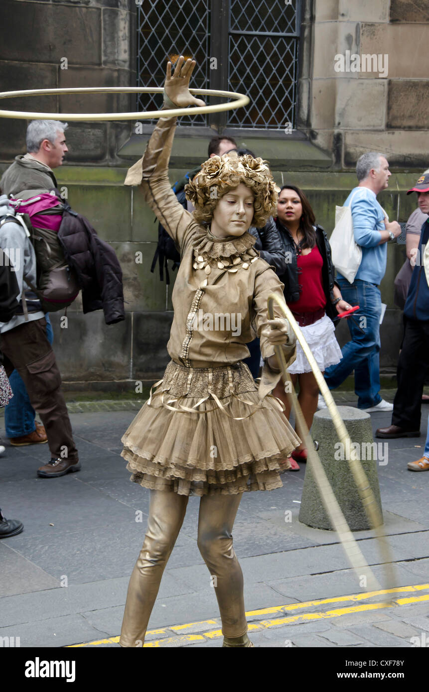 Gold-painted woman spinning hoops during Festival Fringe in Edinburgh ...