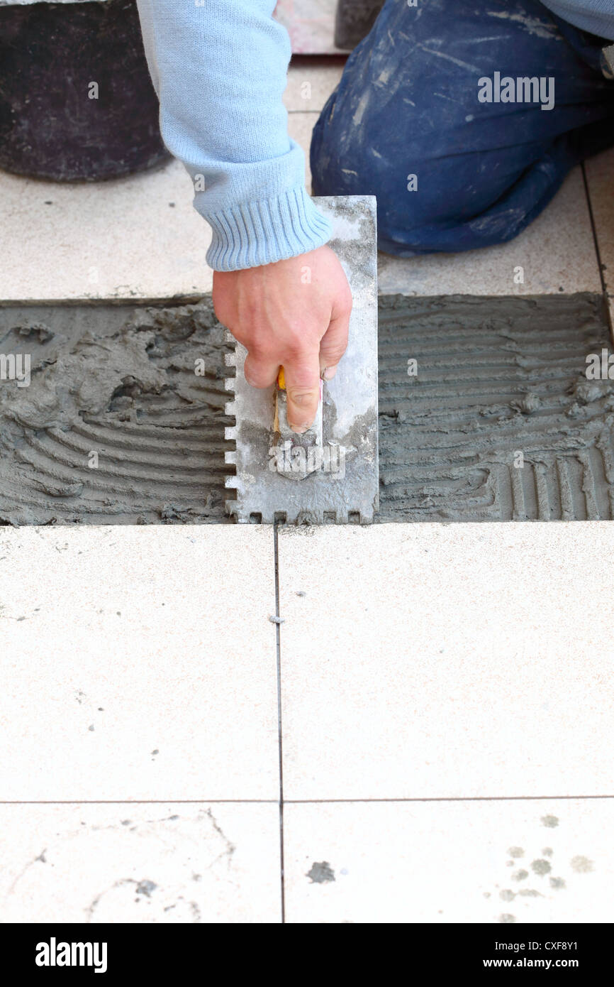 Man Construction worker is tiling at home Stock Photo - Alamy