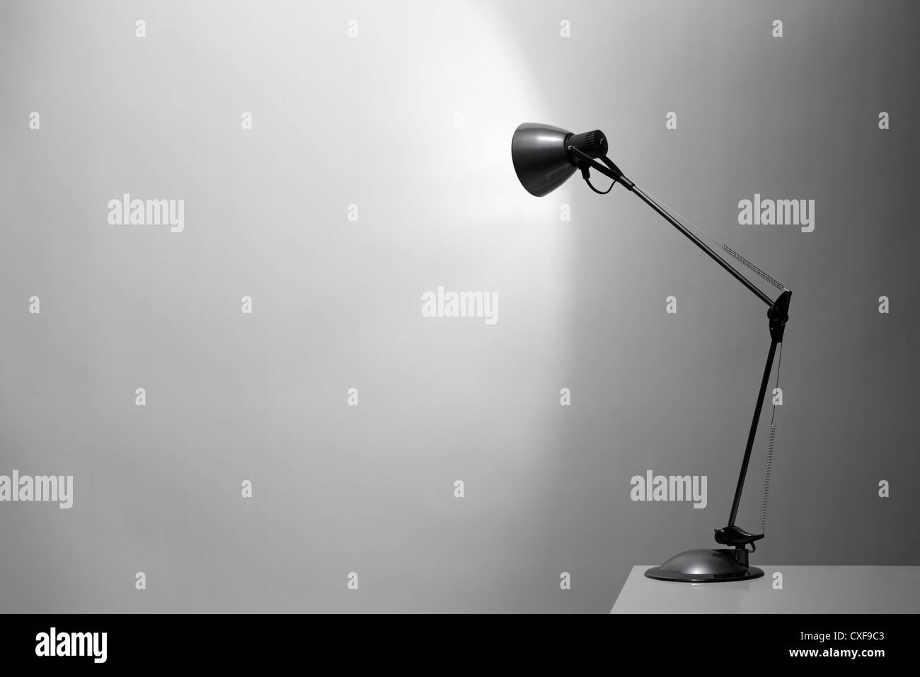 A Grey desk lamp pointed at a grey wall Stock Photo - Alamy