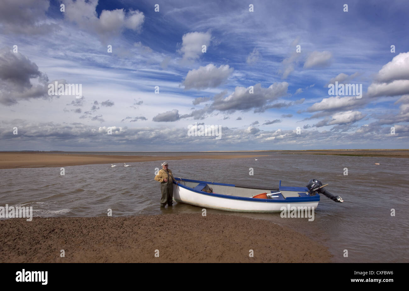 Mussel fisherman returning on river Stiffkey in Blakeney Harbour ...