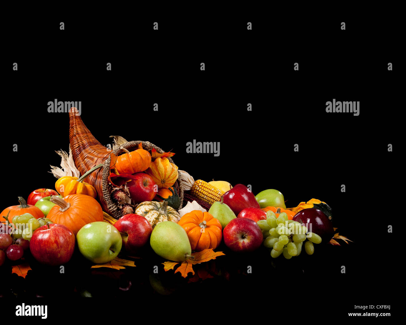 Overflowing cornucopia on a black background Stock Photo - Alamy