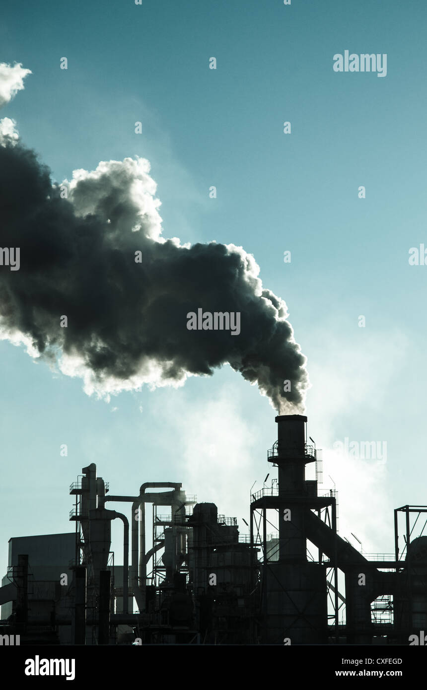 Smoking chimney at sunset on industrial buildings complex Stock Photo ...