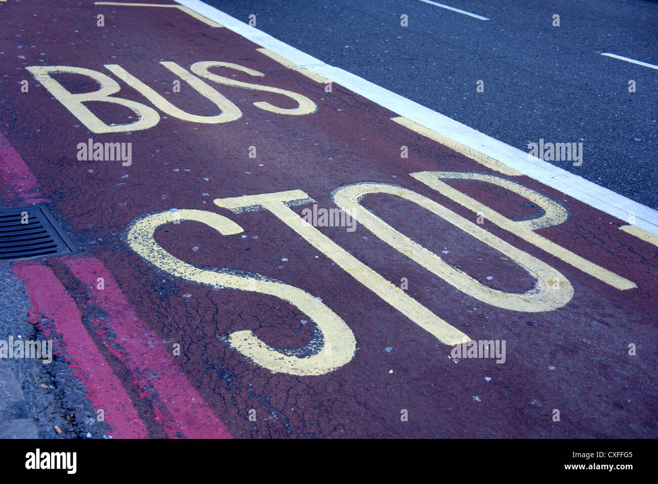 Bus stop sign painted on red bus lane Stock Photo - Alamy