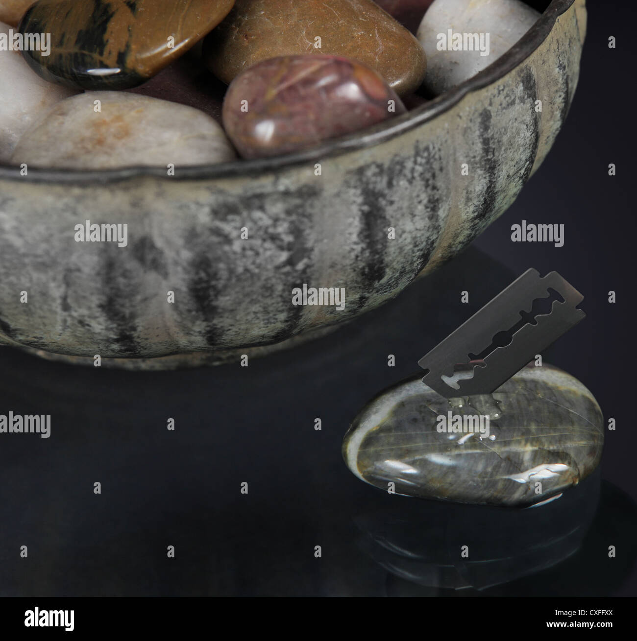 a razor blade makes an incision in a granite stone and out trickles ...