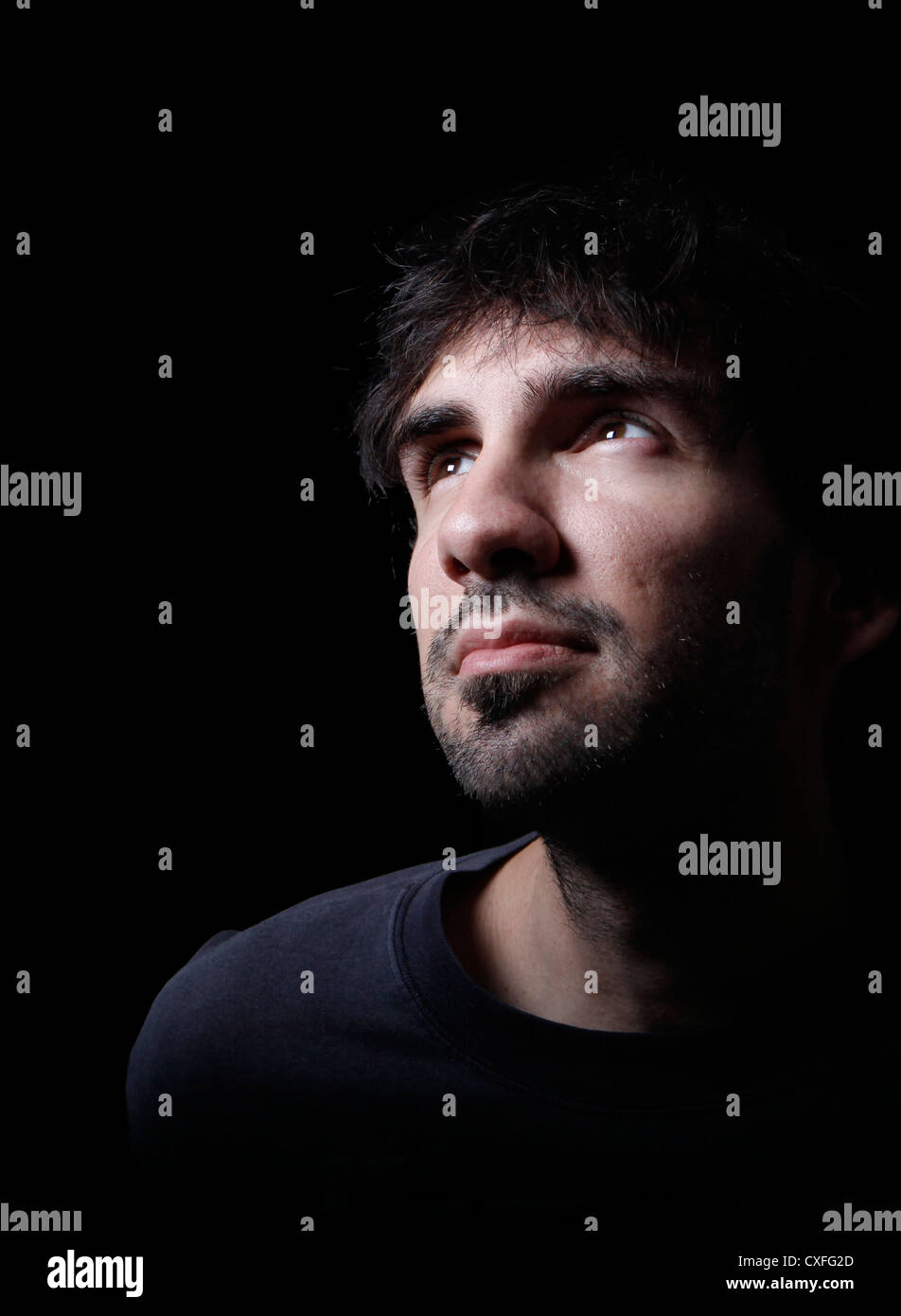 Man looking to the left a light illuminating his face Stock Photo - Alamy