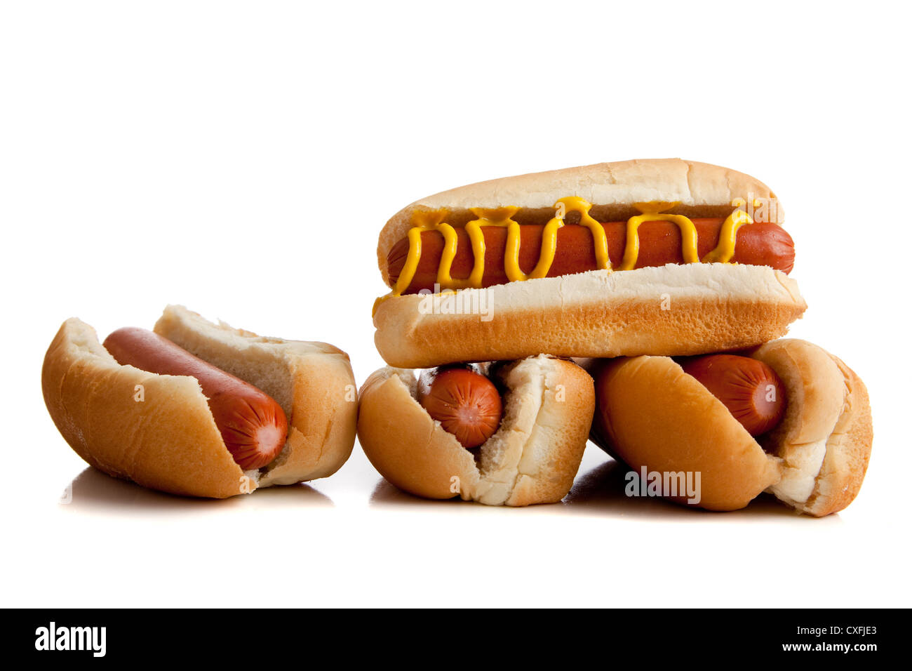 Stack of hot dogs on buns with mustard on a white background with copy ...