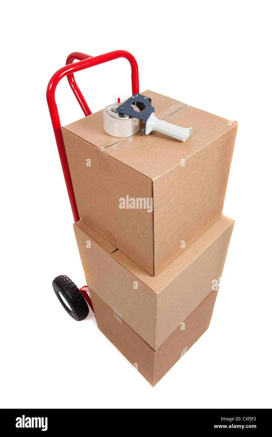 Stack of brown packing boxes with a tape gun on a red hand truck on a ...