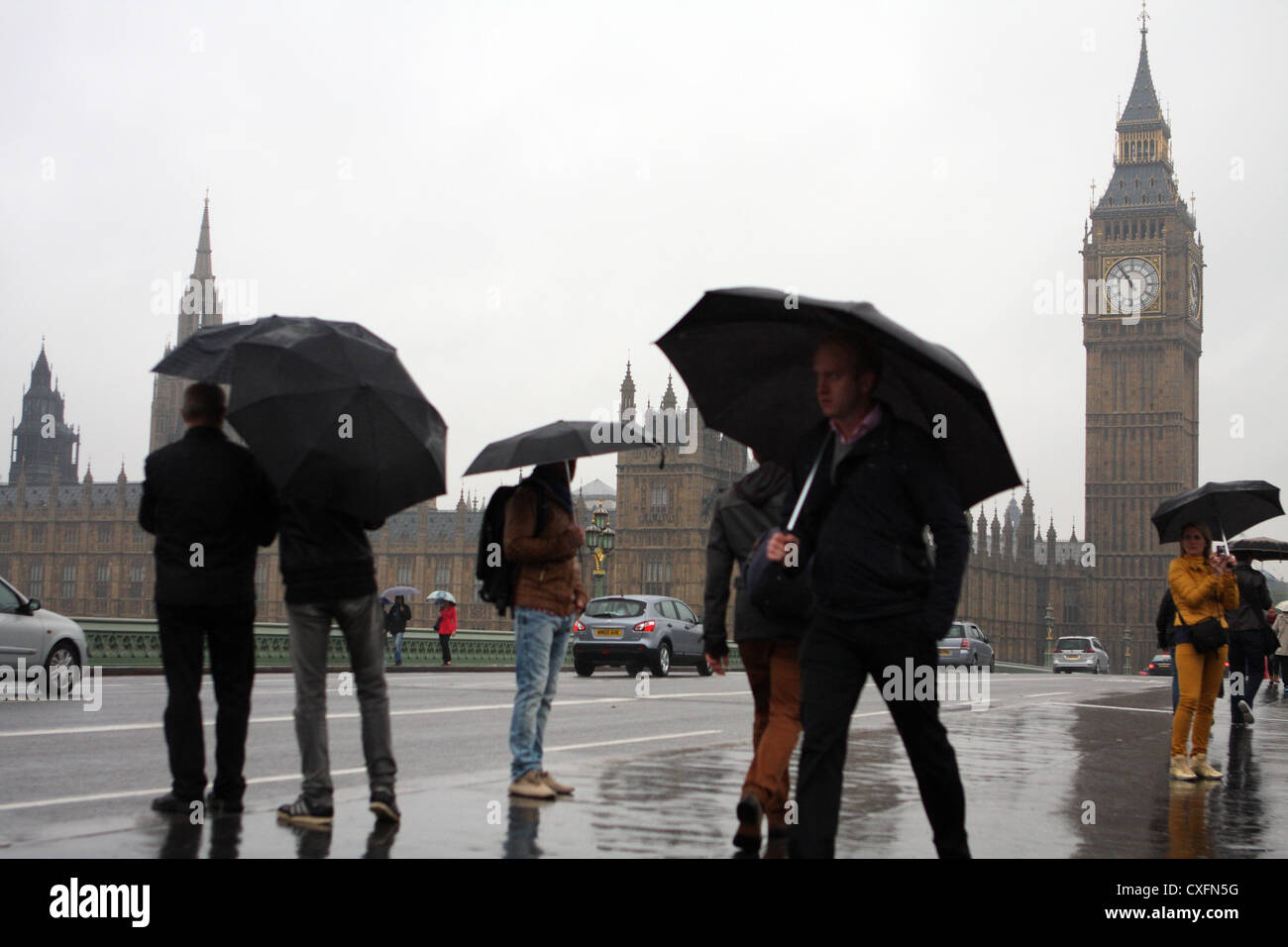People walking across Westminster Bridge in the rain with Big Ben in ...