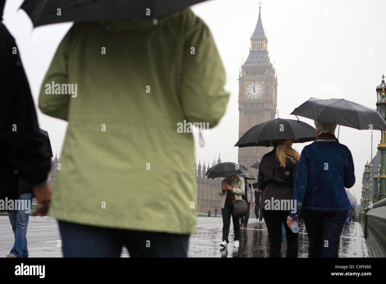 People walking across Westminster Bridge in the rain with Big Ben in ...