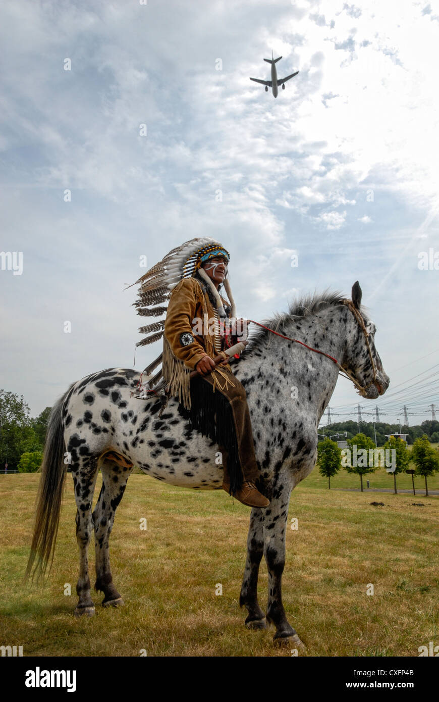 Native American in traditional dress sitting on a horse in an urban ...