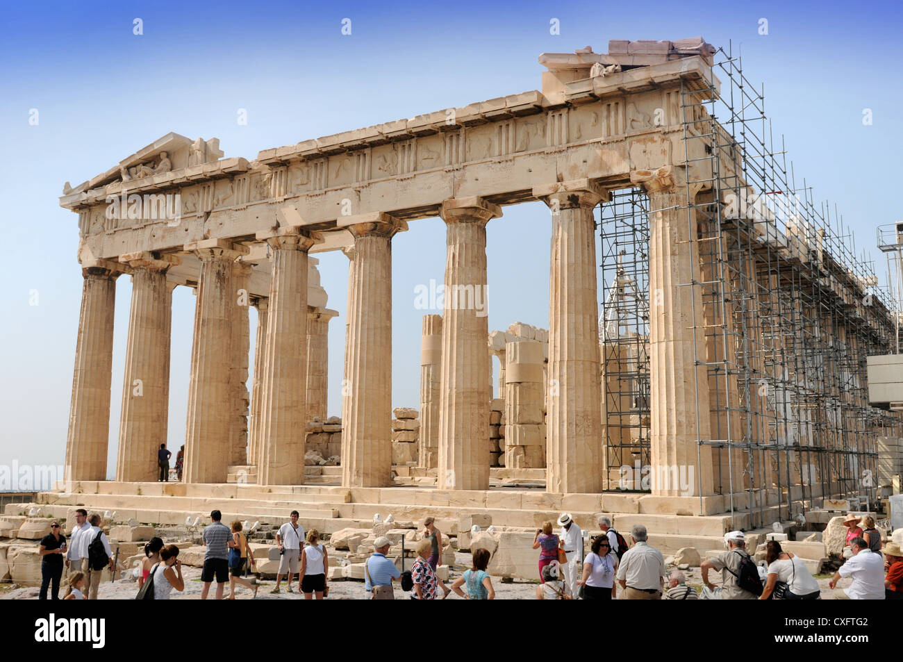 Tourists view the Parthenon temple undergoing restoration work on the Acropolis in Athens ...