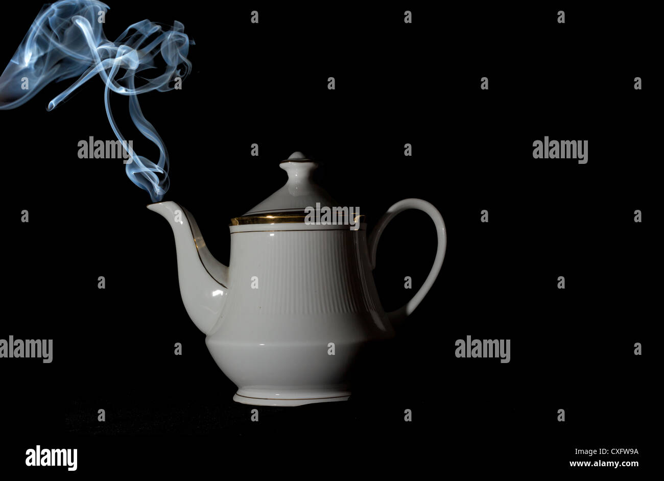 Smoke coming out of isolated teapot on black background Stock Photo - Alamy