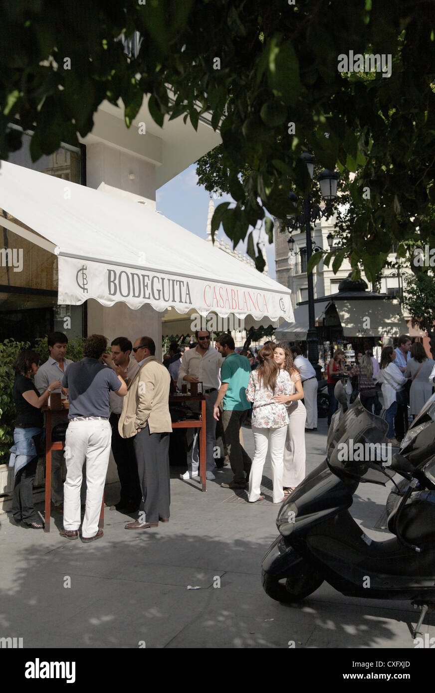 People gathered outside a wine bar or Bodega in cental Seville Stock ...
