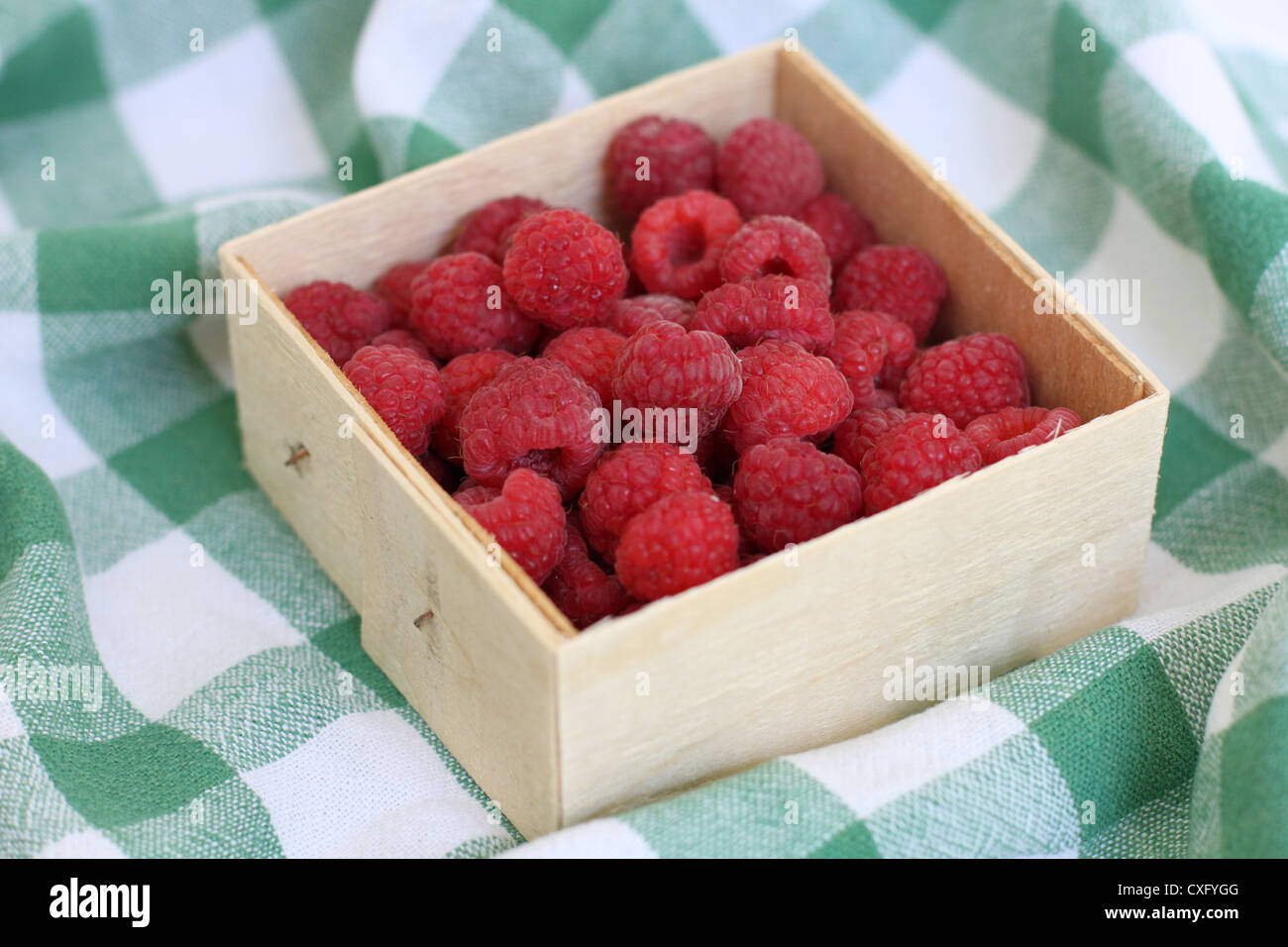 A small wooden box filled with raspberries Stock Photo - Alamy