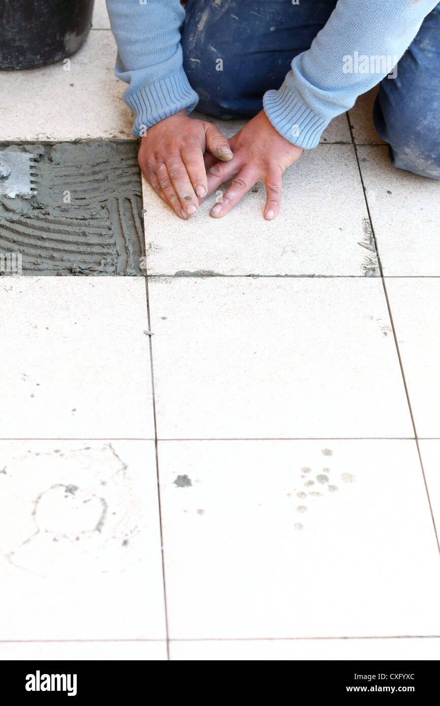 Man Construction worker is tiling at home Stock Photo - Alamy