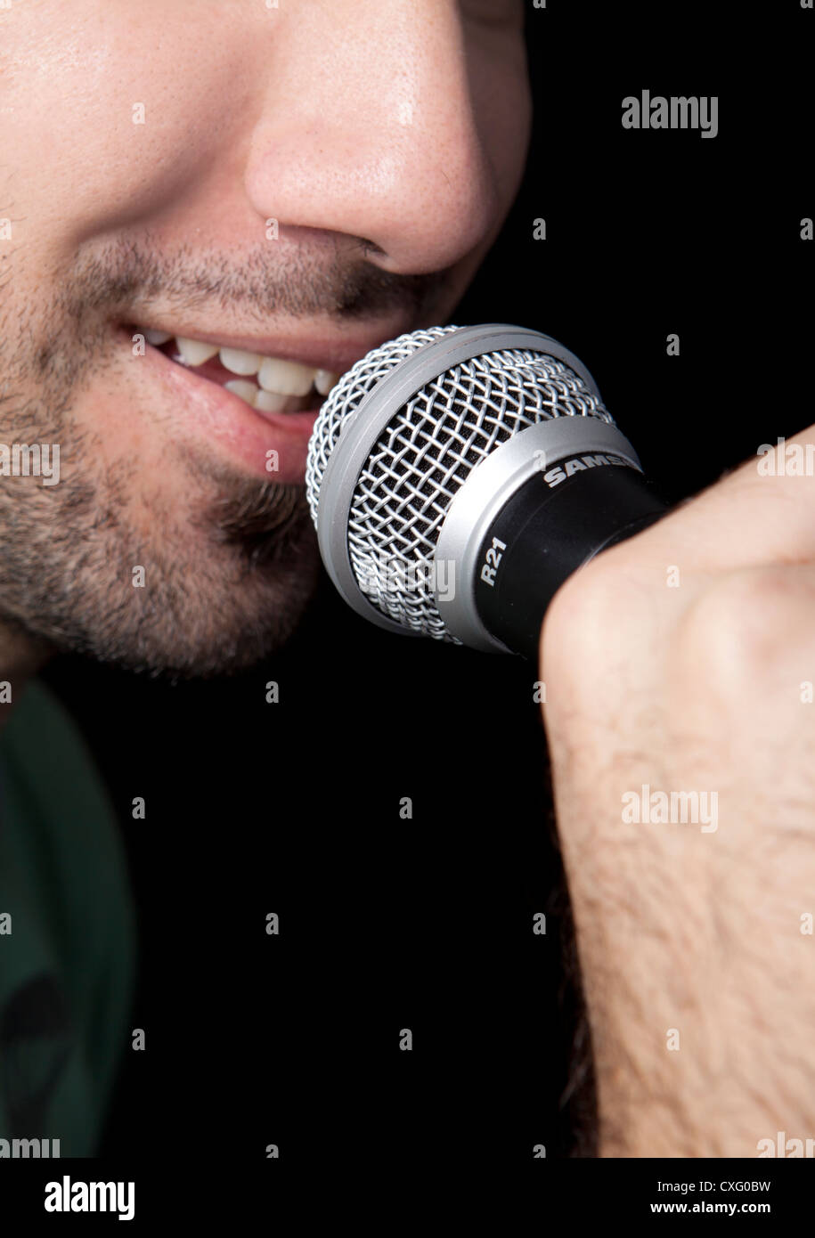 A man singing to a microphone Stock Photo - Alamy