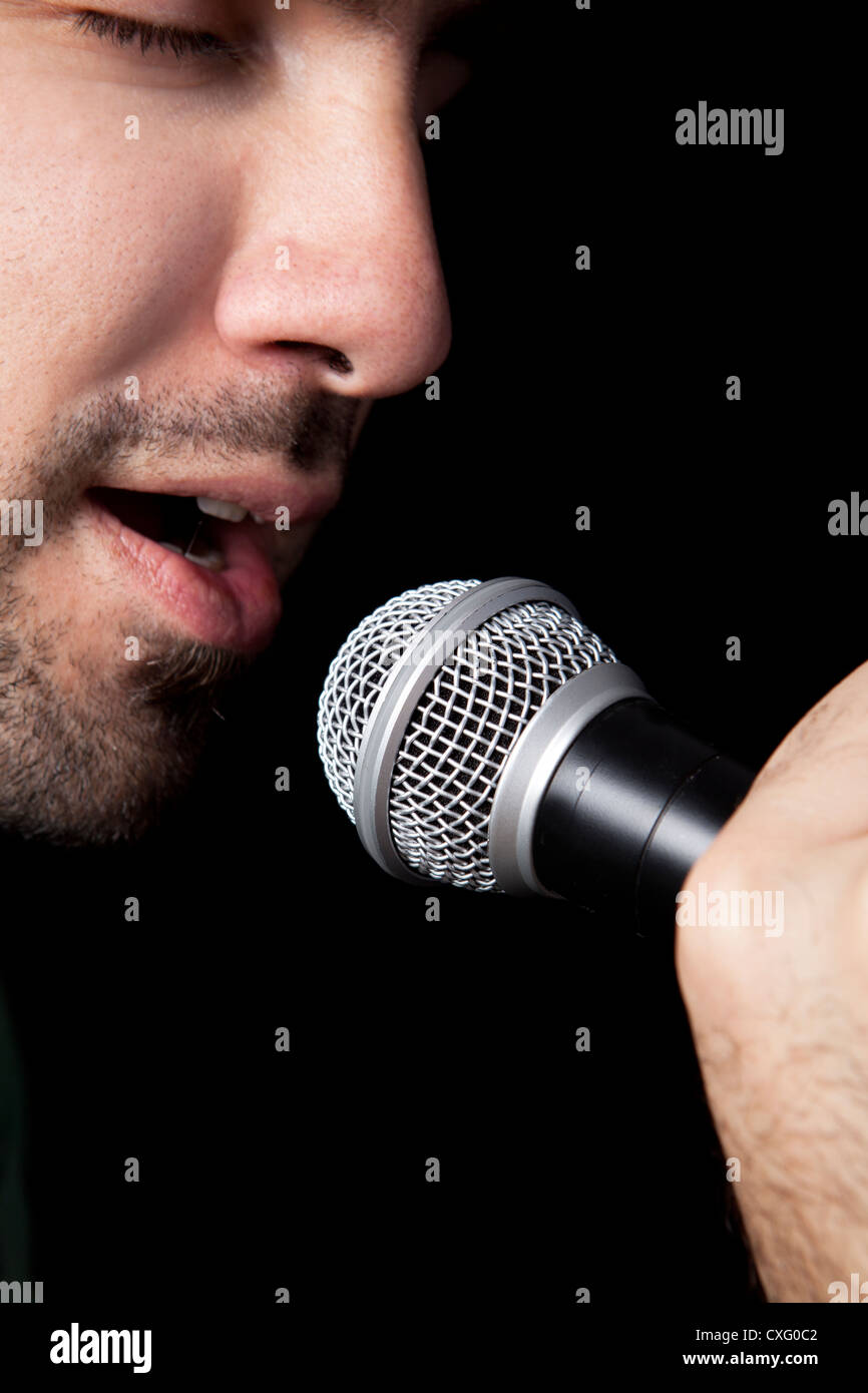 A man singing to a microphone Stock Photo - Alamy