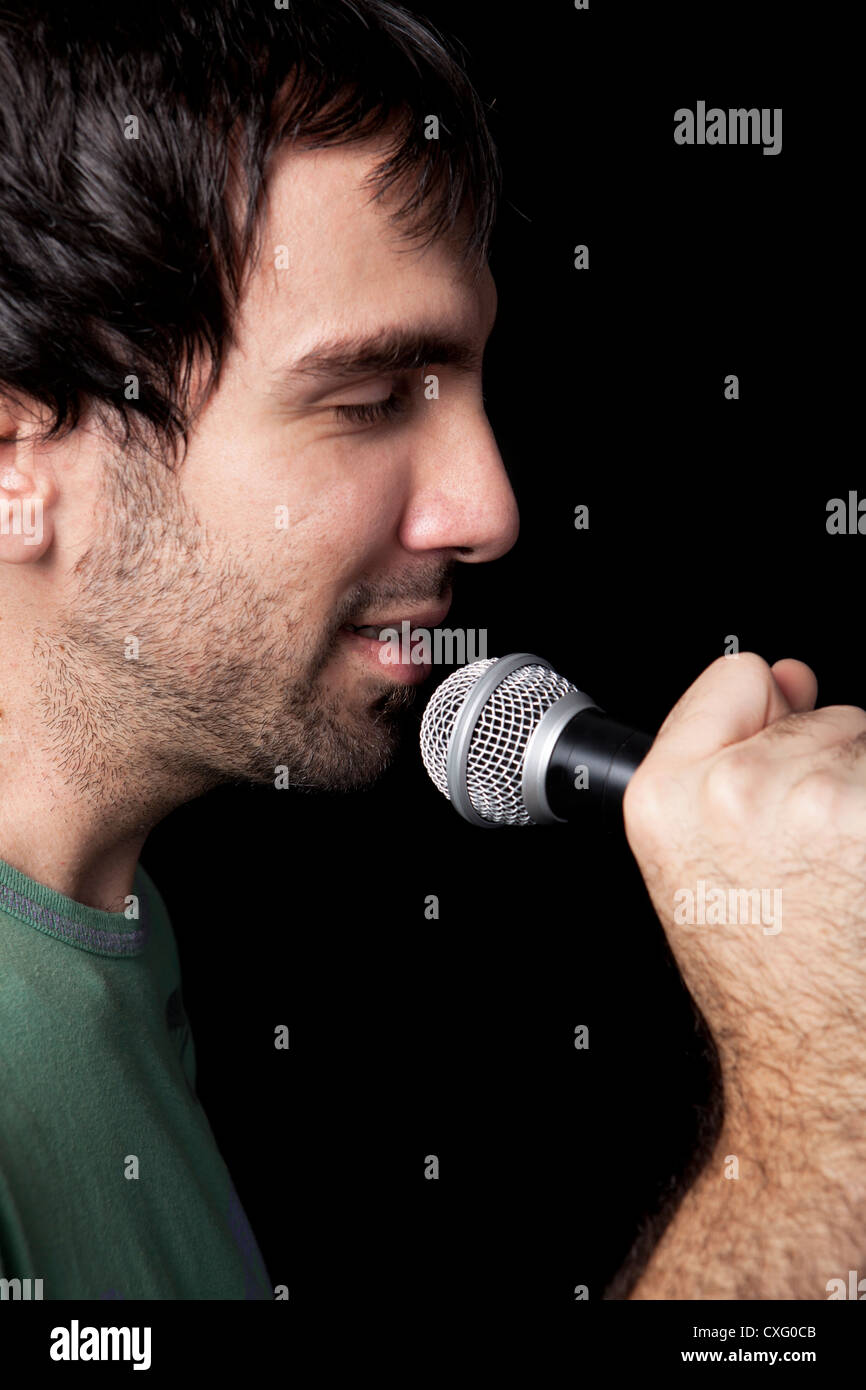 A man singing to a microphone Stock Photo - Alamy