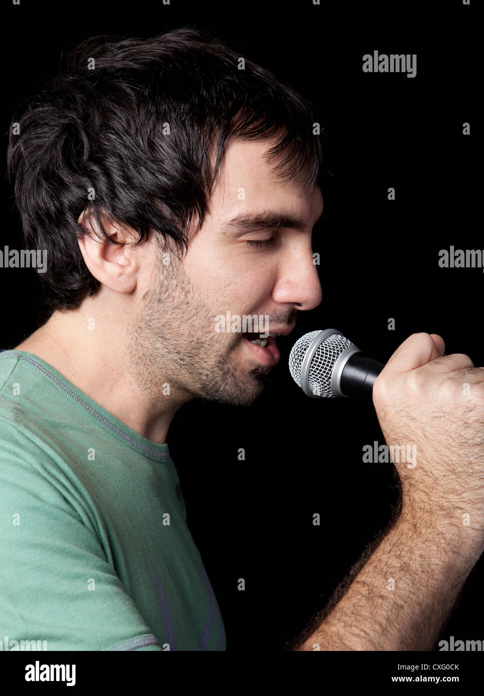 A man singing to a microphone Stock Photo - Alamy