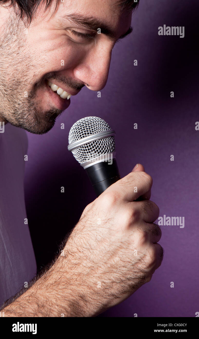 A man singing to a microphone Stock Photo - Alamy