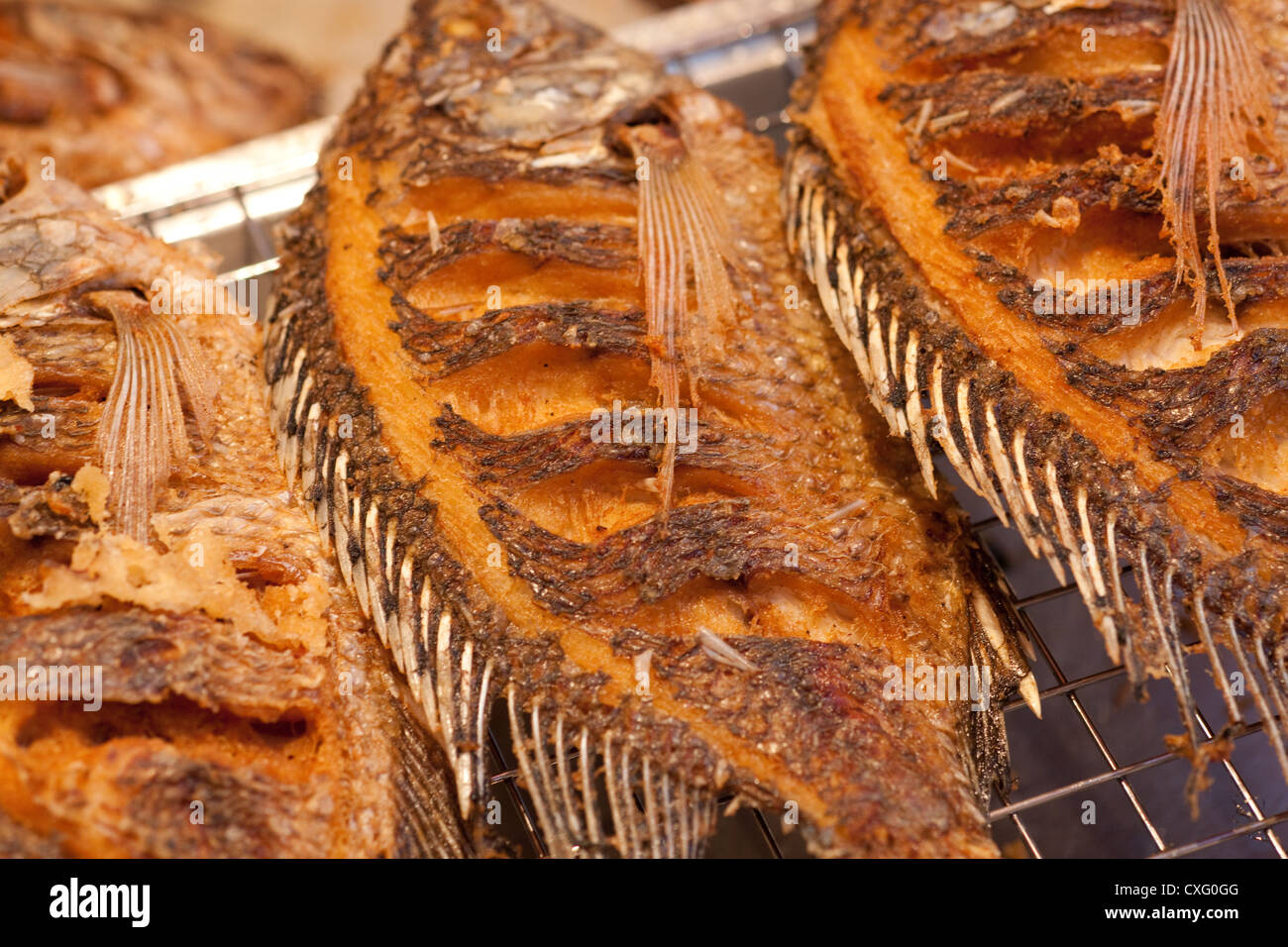 Fried fish on a wire rack in a market in Bangkok Thailand Stock Photo ...