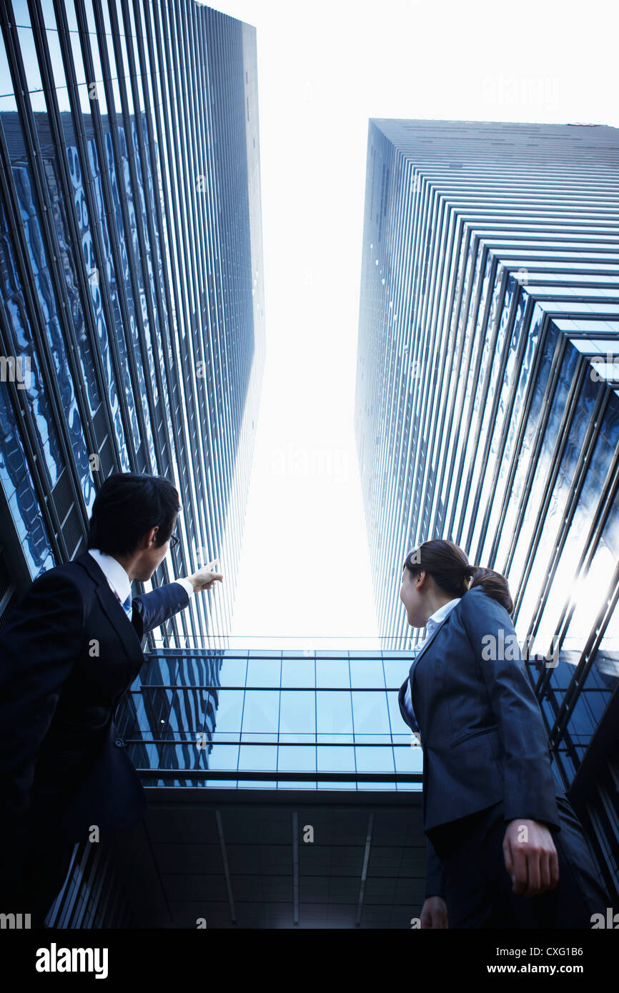 A business man with a business woman pointing at the roofs of joined ...