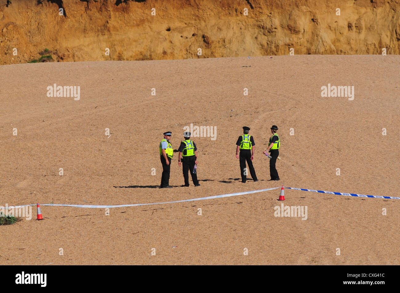 Police working in a cordoned off area on a beach UK Stock Photo - Alamy