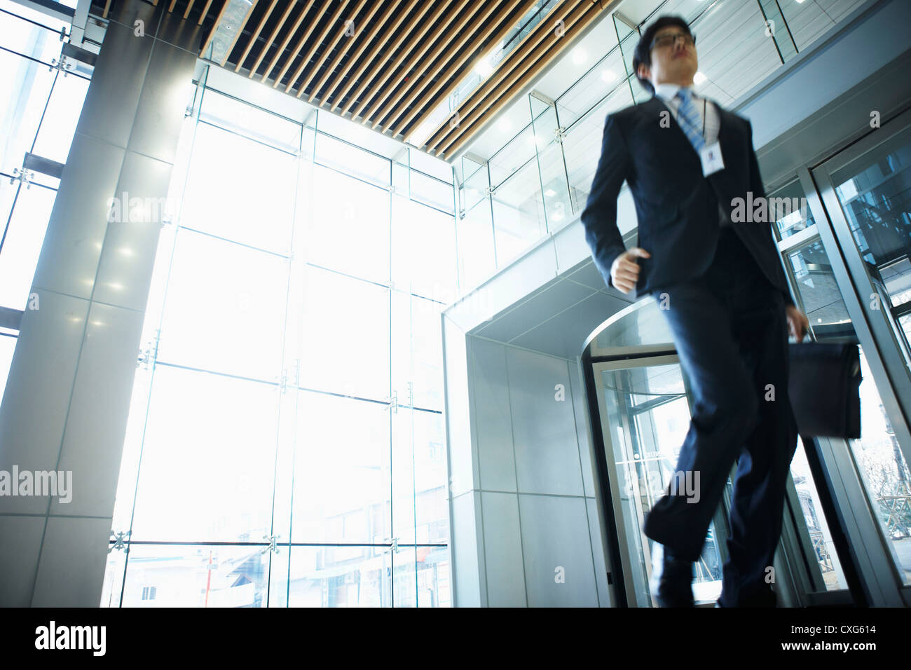 A business man with a briefcase man running into an office building ...