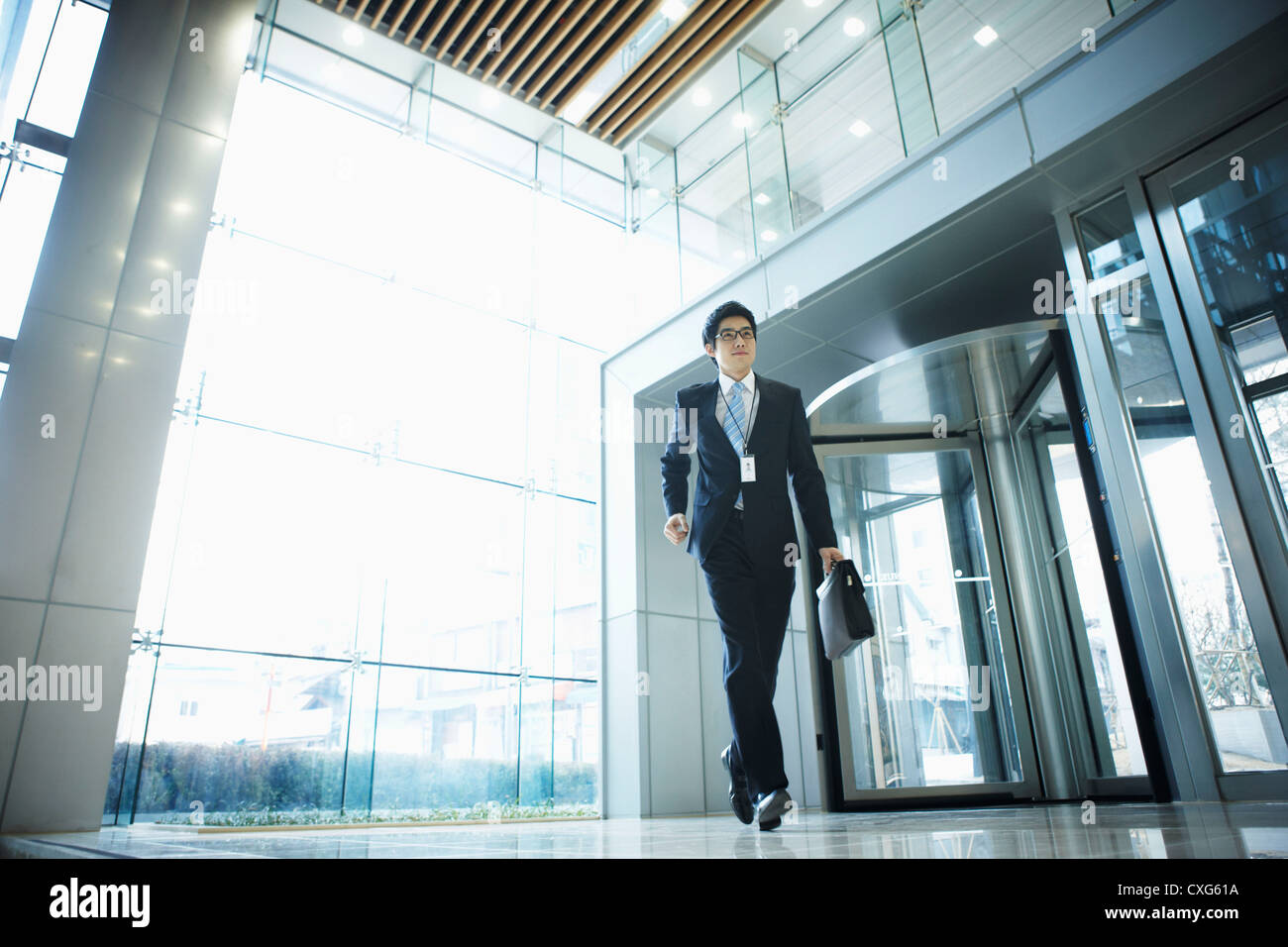 A business man with a briefcase man running into an office building ...