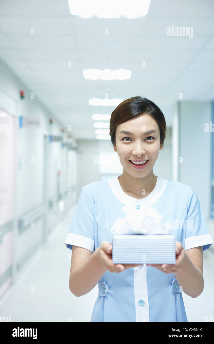 A nurse standing with a present in an empty corridor Stock Photo - Alamy