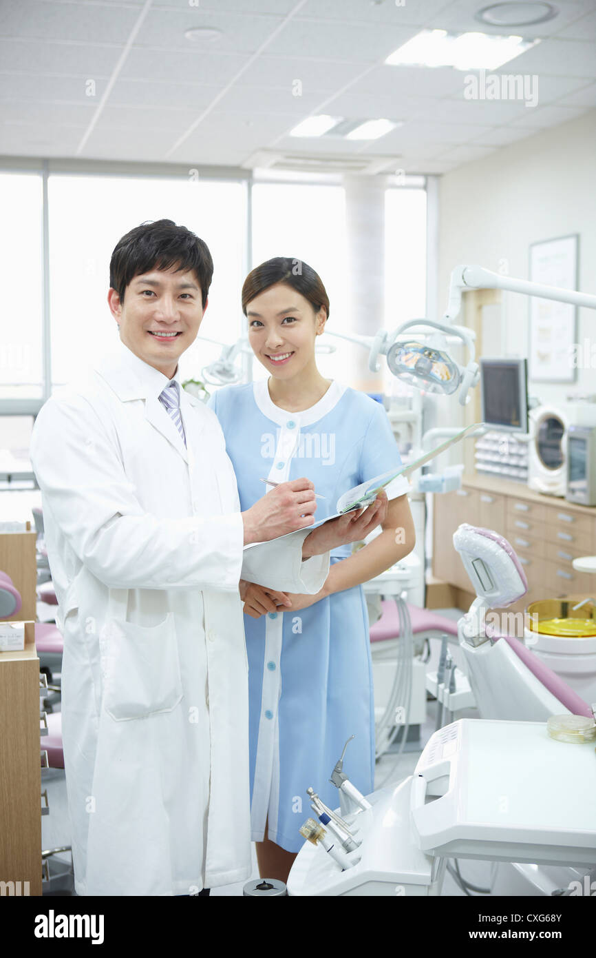 A dentist and a nurse standing in a dental treatment room Stock Photo ...