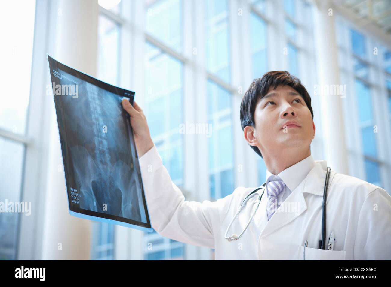 A doctor in a white dressing gown with stethoscope around his neck ...
