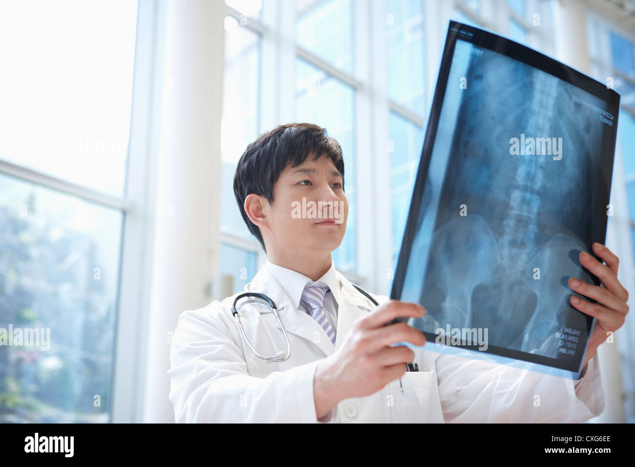 A doctor in a white dressing gown with stethoscope around his neck ...