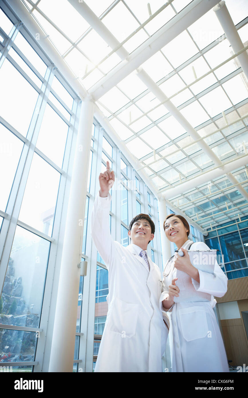 A male doctor pointing while a female doctor holding a report Stock ...
